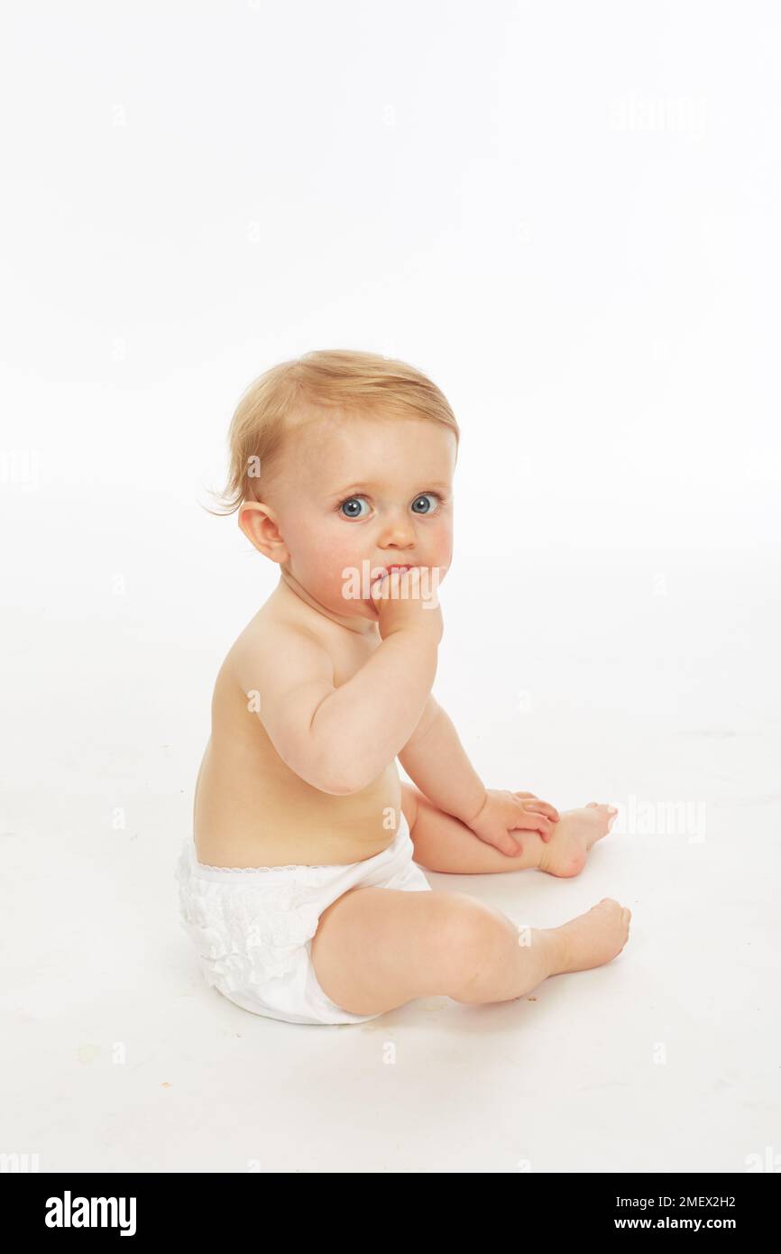 Baby in nappy sitting (Model age - 9 months Stock Photo - Alamy