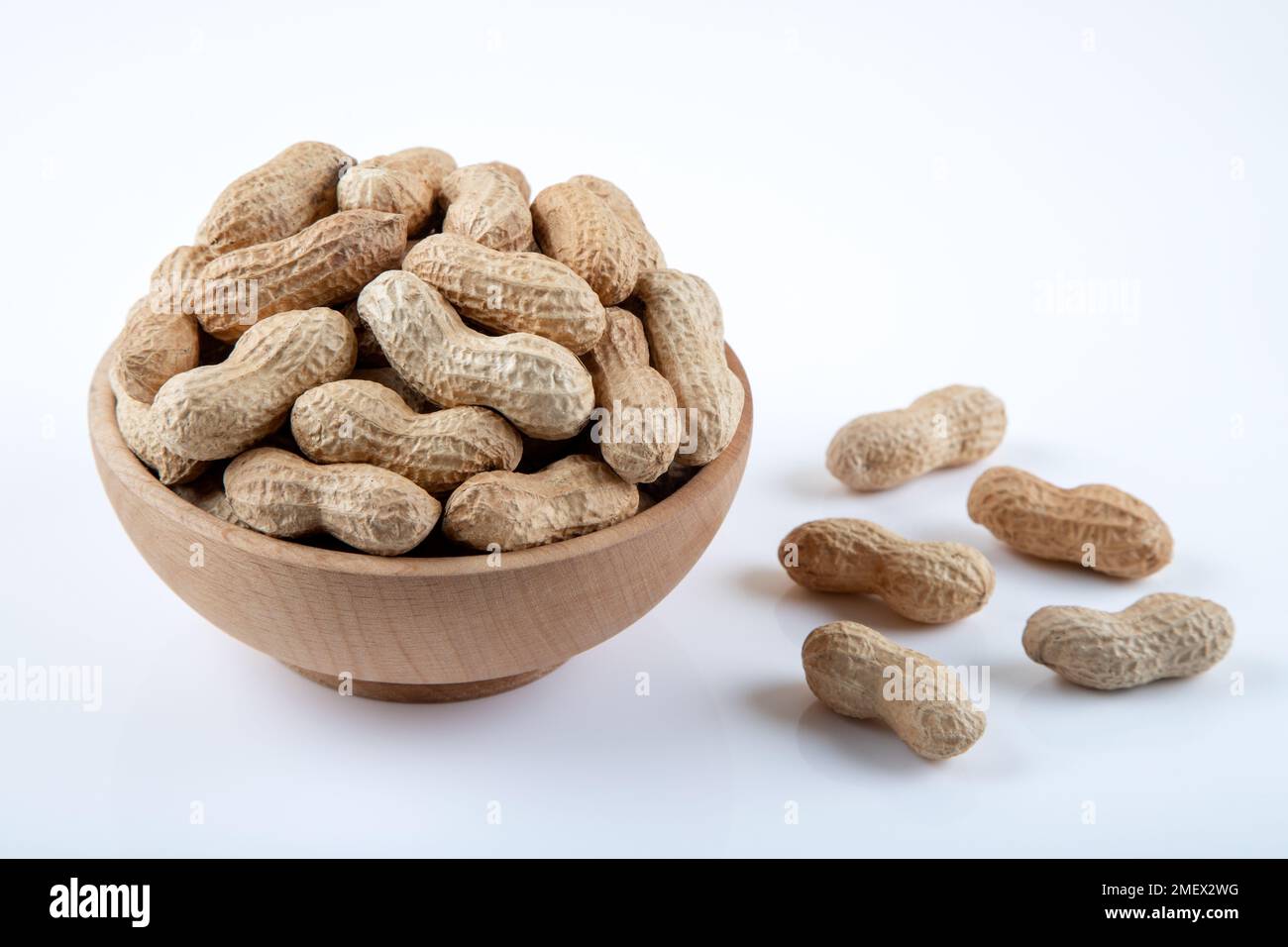 Bowl full of shelled peanuts on white background Stock Photo - Alamy