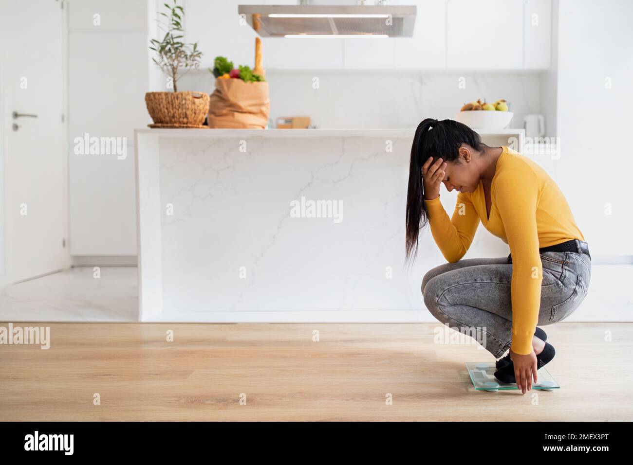 Sad millennial african american woman in casual crying on scales ...