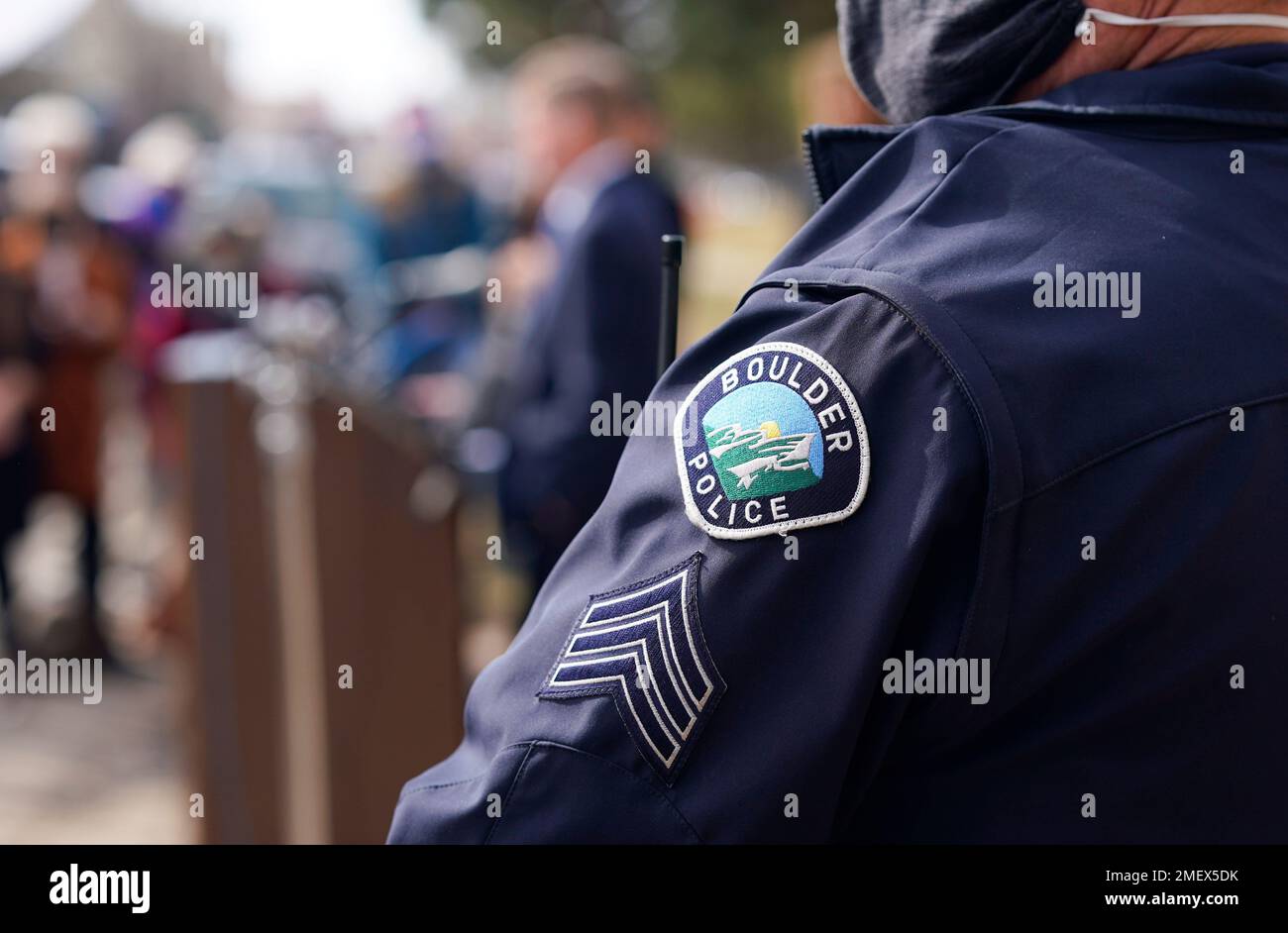 As an officer stands watch in the foreground, Boulder County, Colo ...