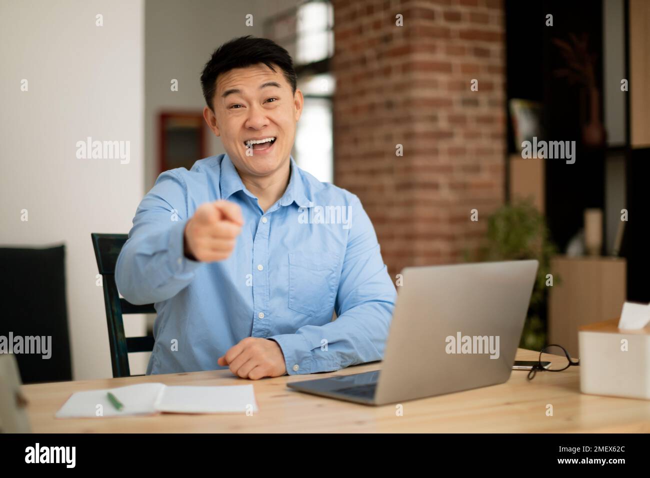 Hey, you. Happy mature asian man pointing finger at camera and smiling ...