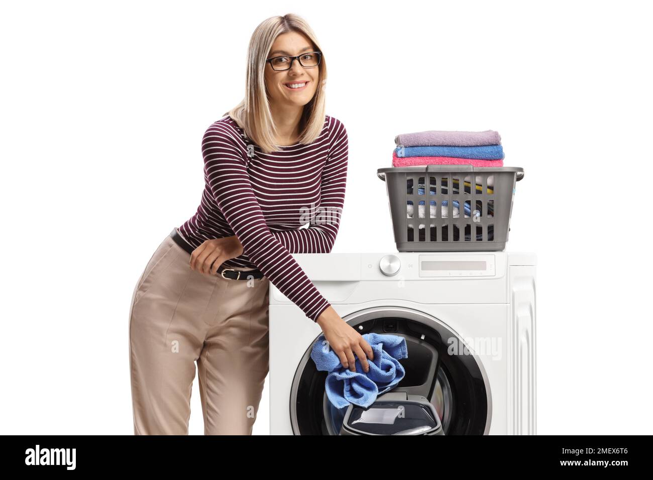 Woman leaning on a washing machine and adding clothes isolated on white ...