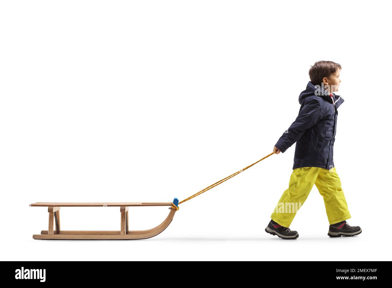 Full length profile shot of a boy pulling a wooden sleigh isolated on ...