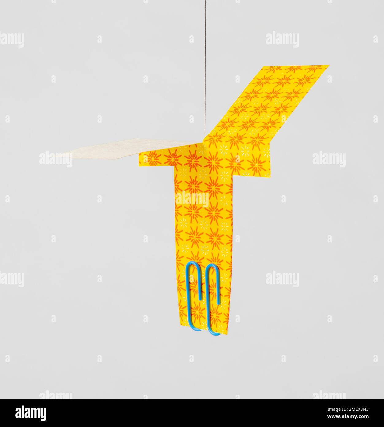 Yellow patterned paper helicopter Stock Photo - Alamy