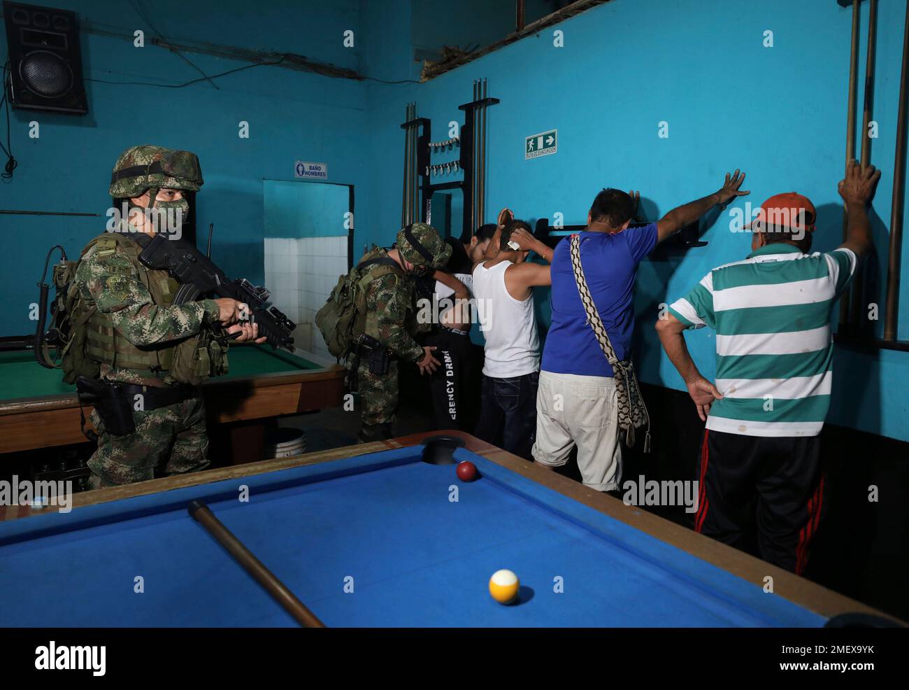 Colombia's army special forces frisk men at a pool hall in Arauquita ...