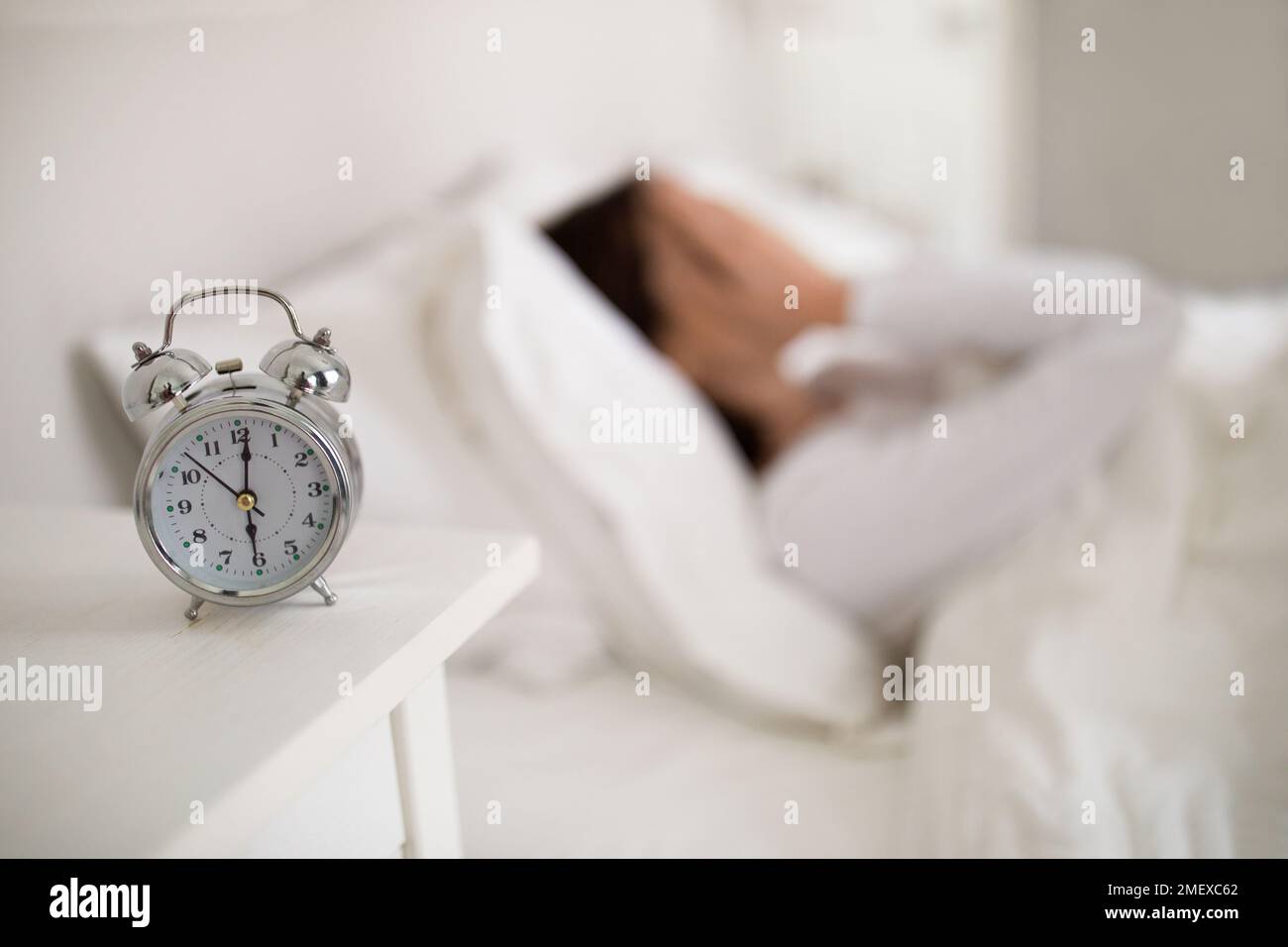 Selective focus on alarm on bedside table over sleeping lady Stock ...