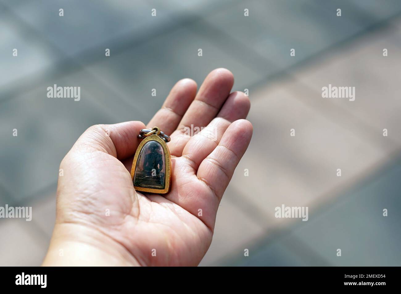 A hand was holding a vintage amulet with gold frame Stock Photo - Alamy