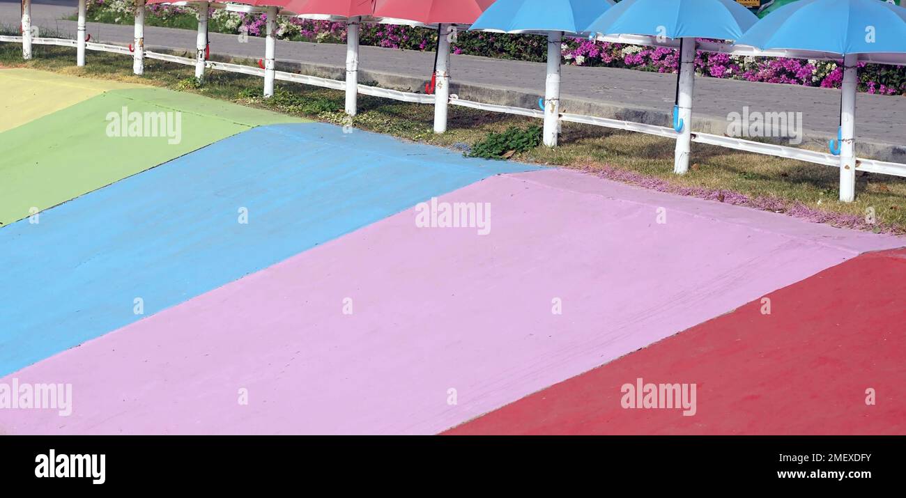 A cements surface slope multi paint color with a multi umbrellas fence ...