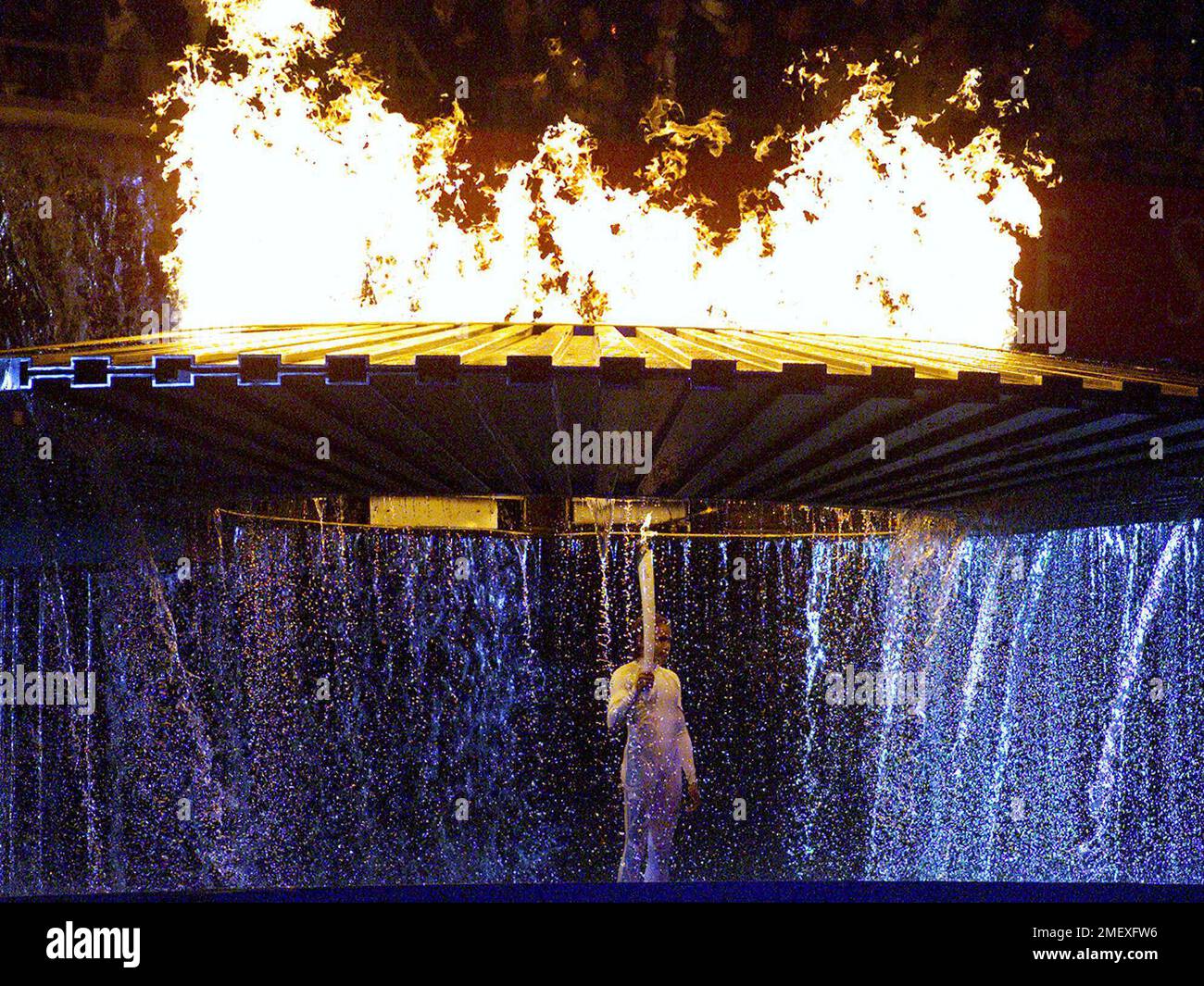 Australian runner Cathy Freeman stands under the Olympic torch after ...