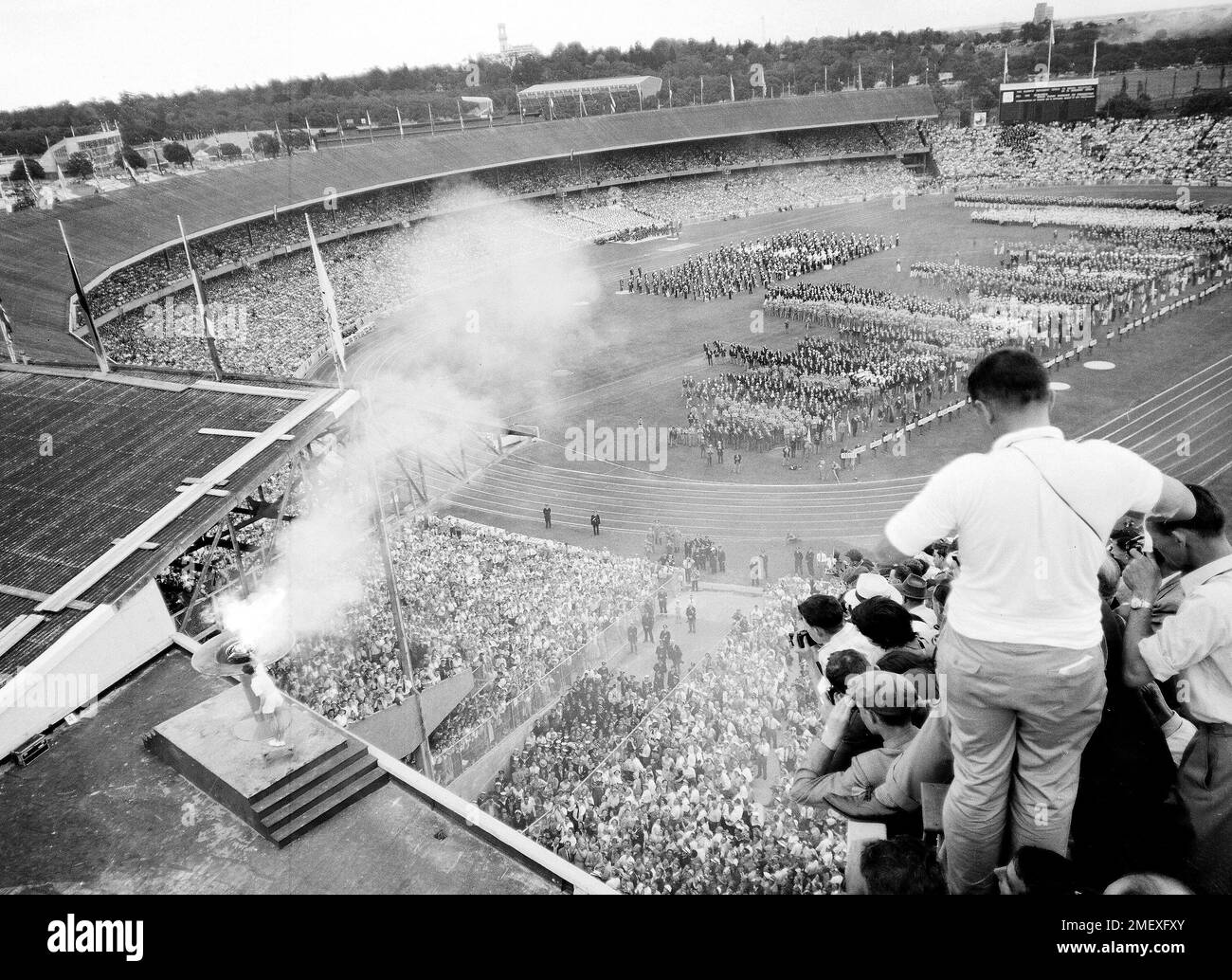 Australian athlete Ron Clark, bottom left, plunges the Olympic torch ...