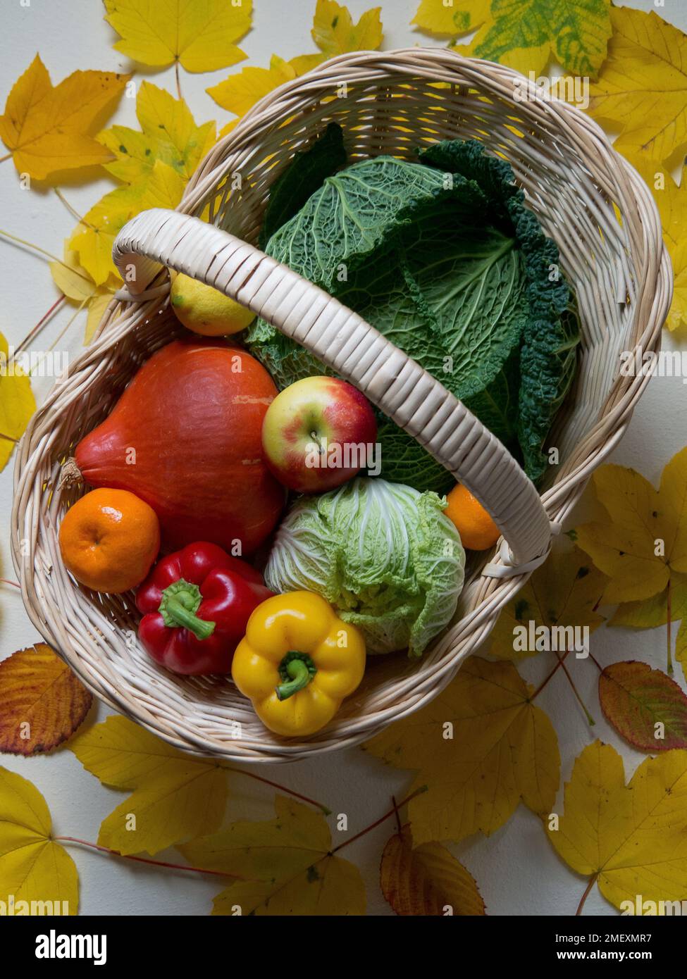 A vertical top view of a wicker basket full of healthy fruits and ...