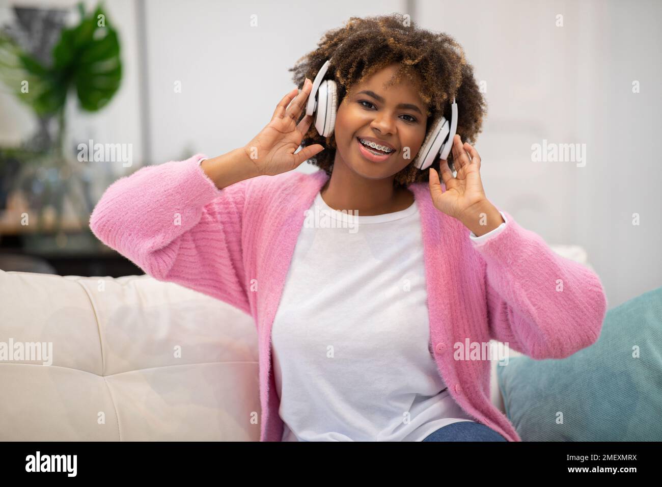 Portrait of happy black woman listening to music at home Stock Photo ...