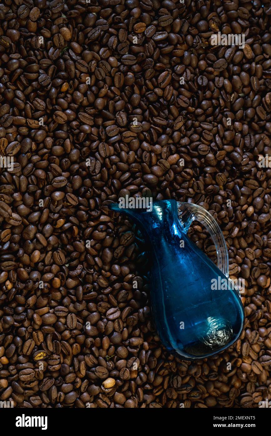 Blue glass vase on a background of coffee beans Stock Photo - Alamy