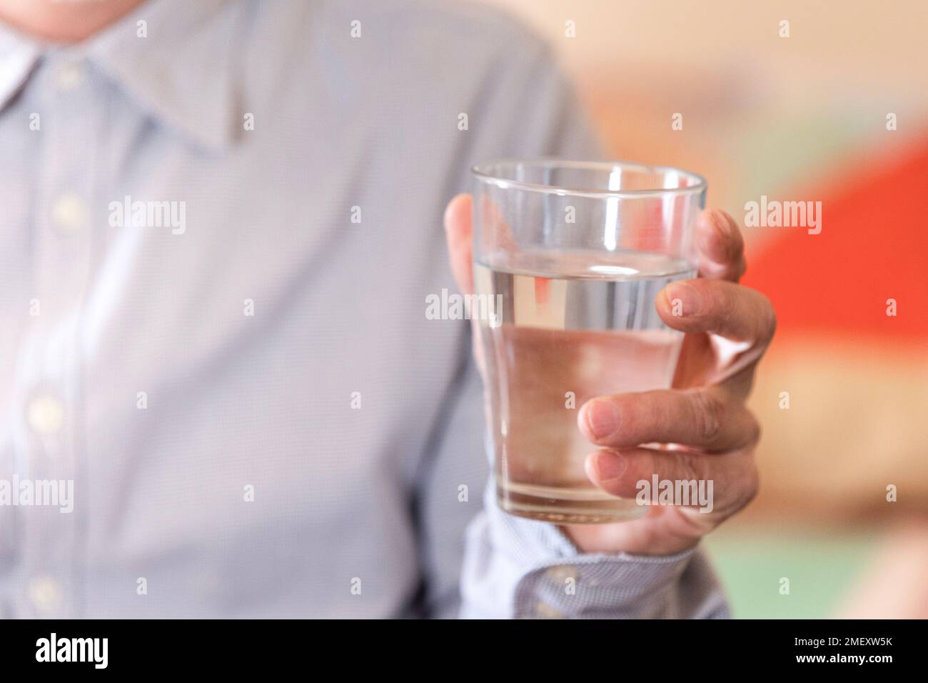 A glass of clean water or mineral water in man's hands. Concept of ...
