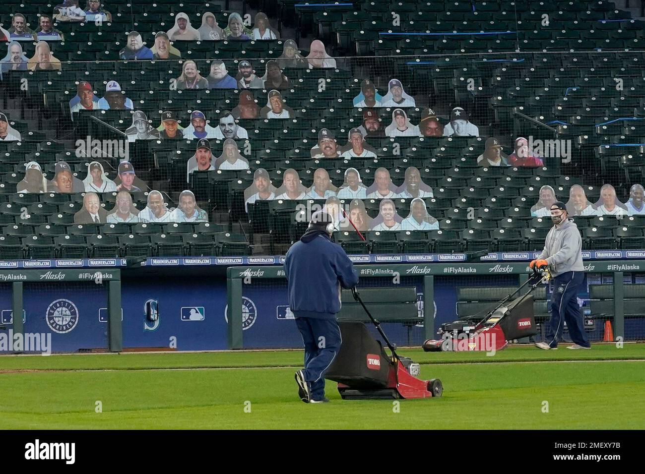 Grounds crew workers mow near the first-base foul line at T-Mobile Park ...
