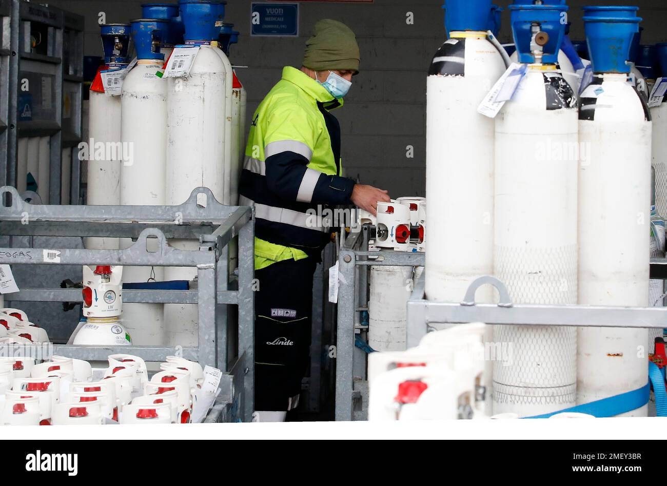 A worker works in a oxygen tanks refill center in Arluno, Italy ...