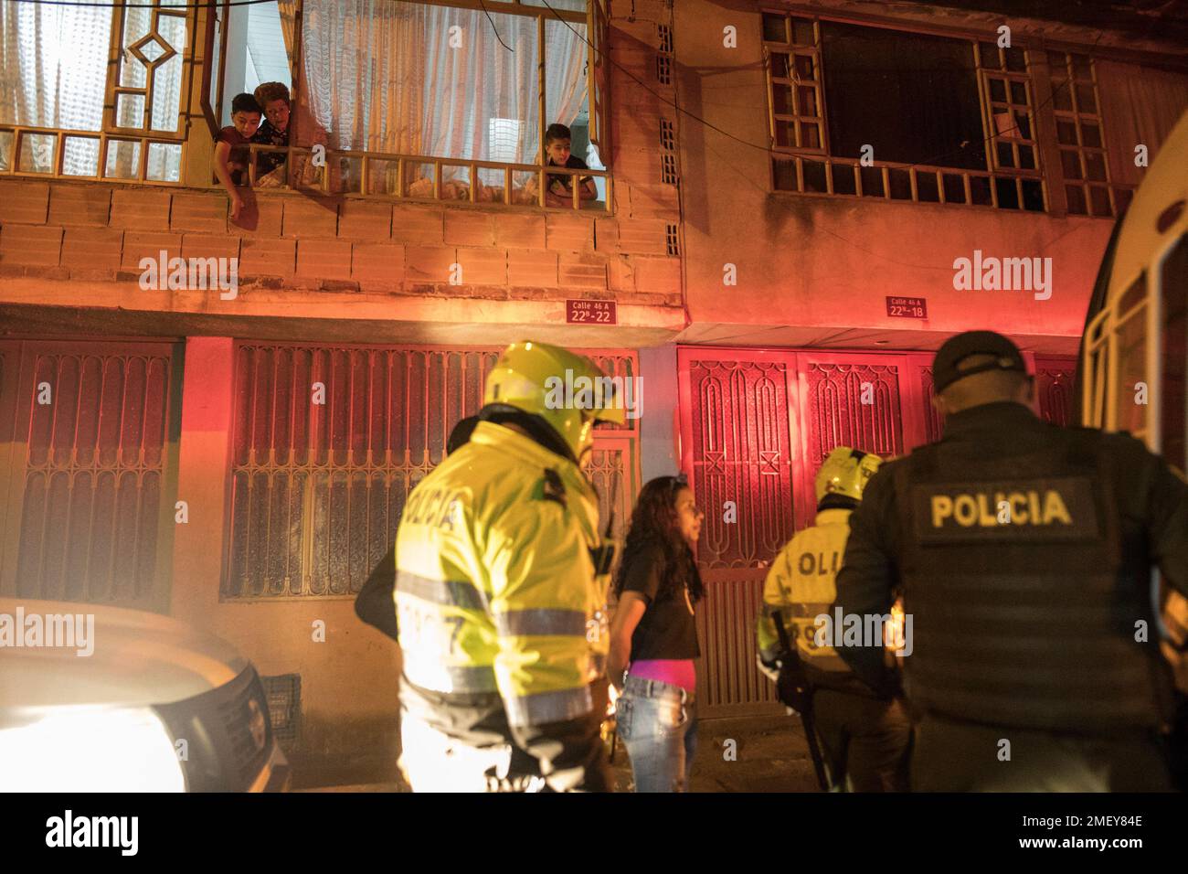 Neighbors watch police attending a call at a bar in Soacha, outskirts ...