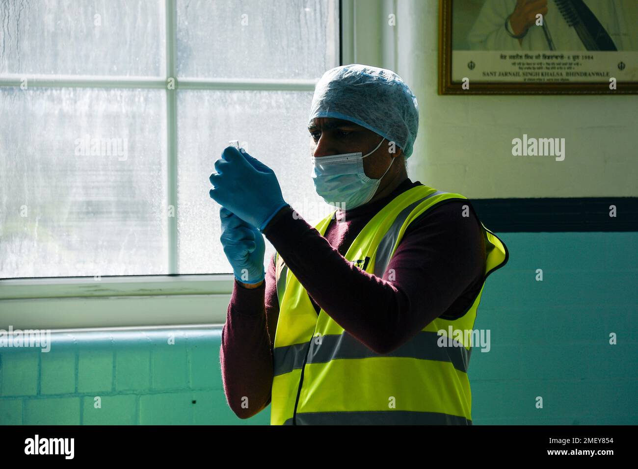 Dr Talib Abubacker prepares a dose of the AstraZeneca COVID-19 vaccine ...