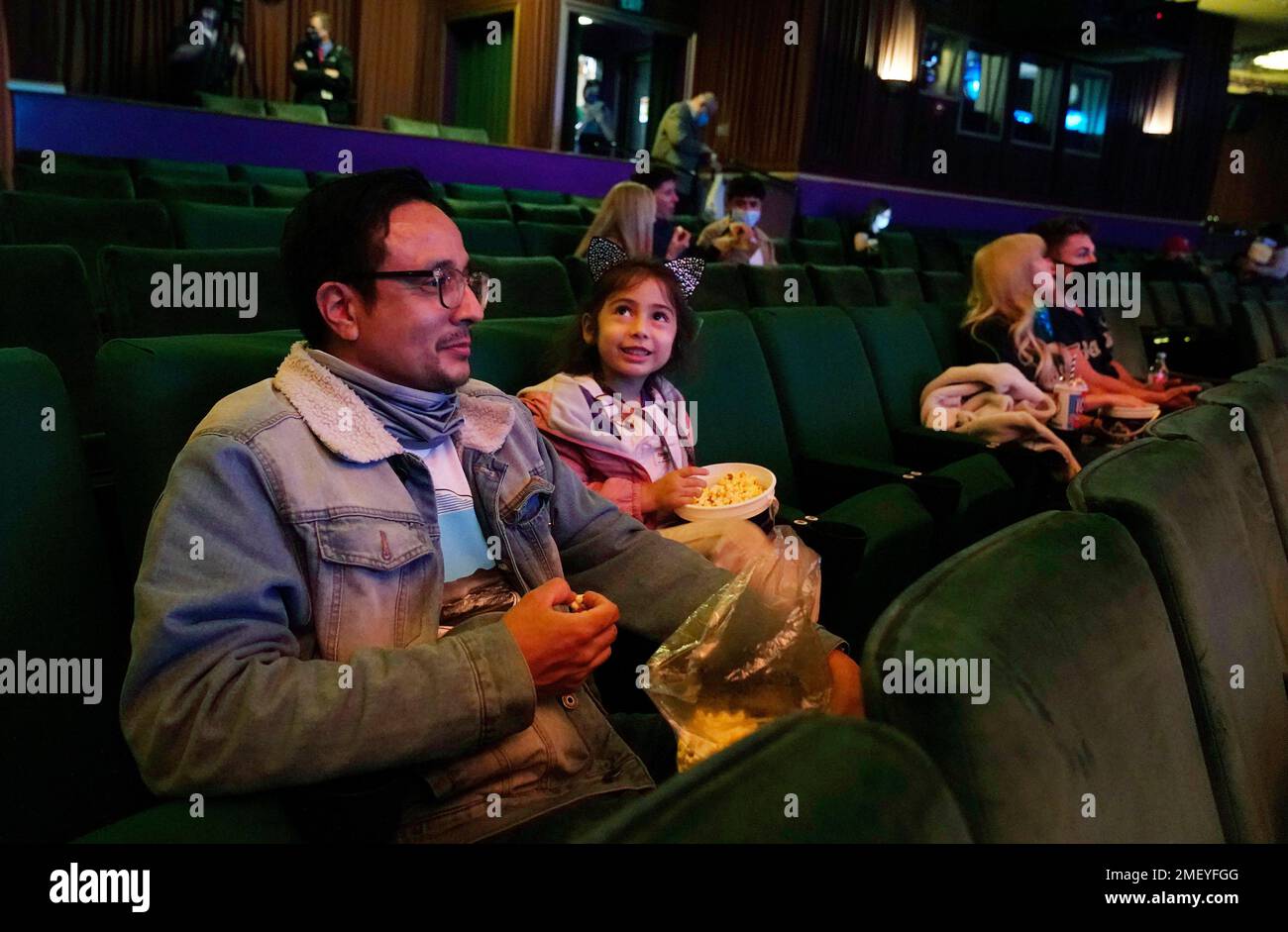 Anthony Helena, left, and his daughter Seraphin, 4, await a screening ...