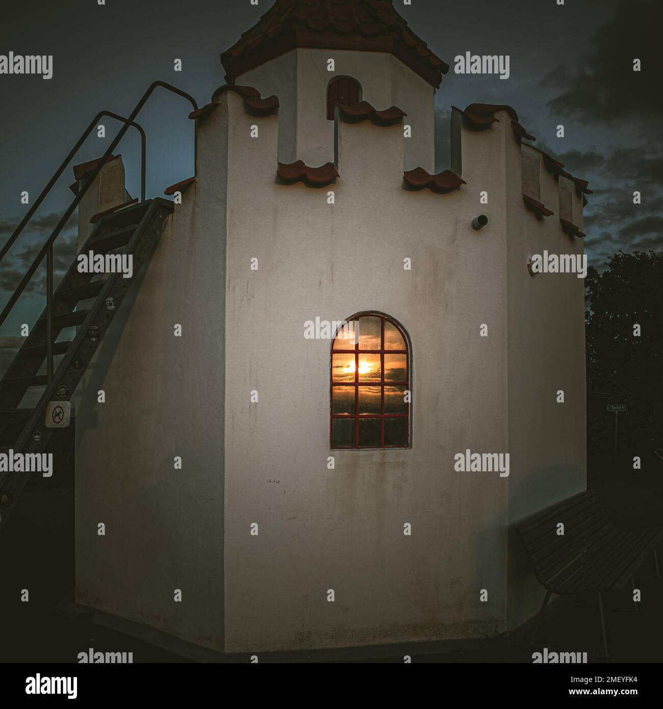 A scene of the white Ballebjerg Watchtower with a beautiful sunset ...