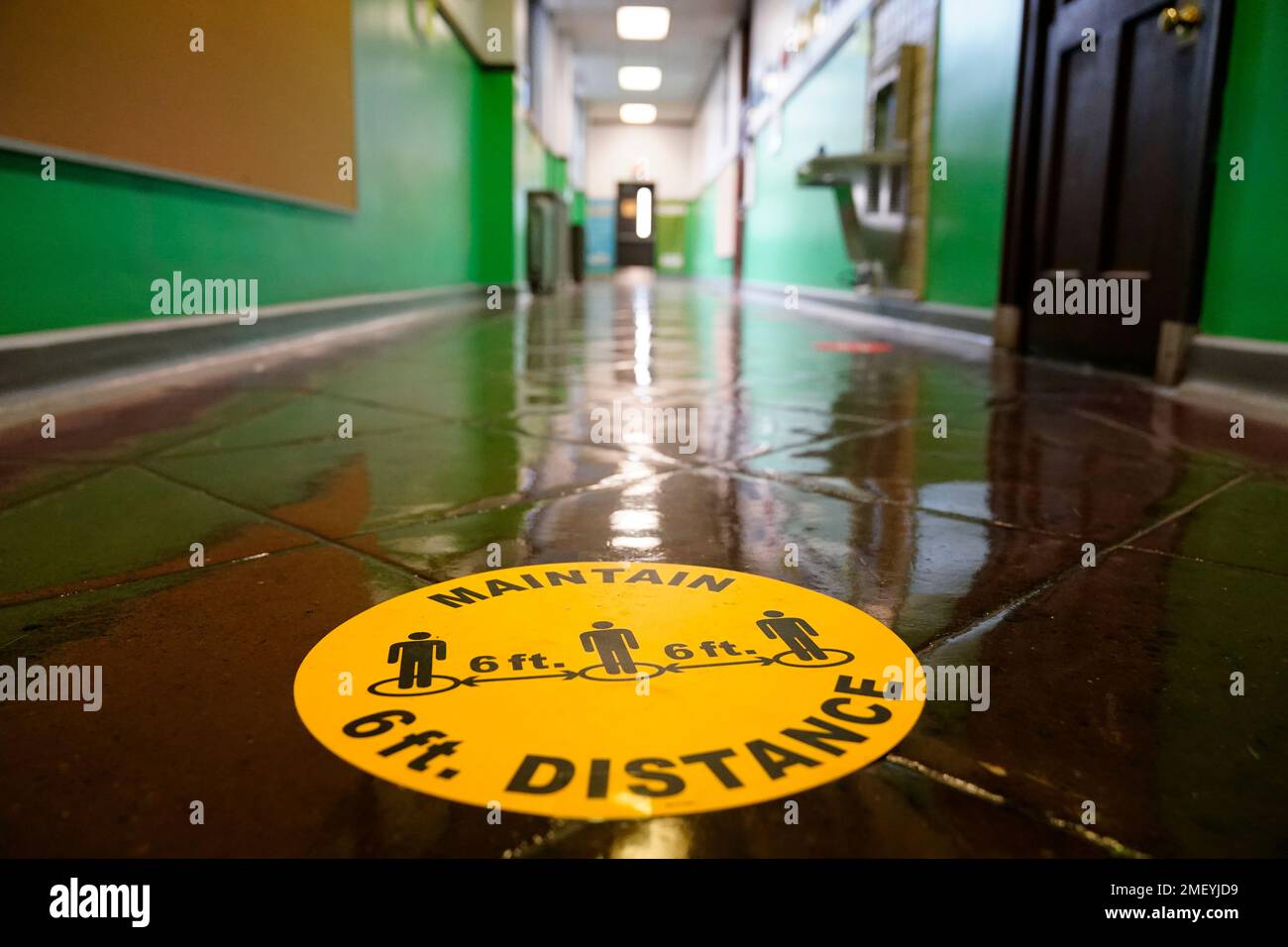A social distancing reminder is posted on a hallway floor of Nebinger ...