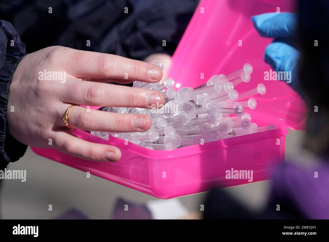 Filled syringes are taken to nurses to be injected at a COVID-19 mass ...