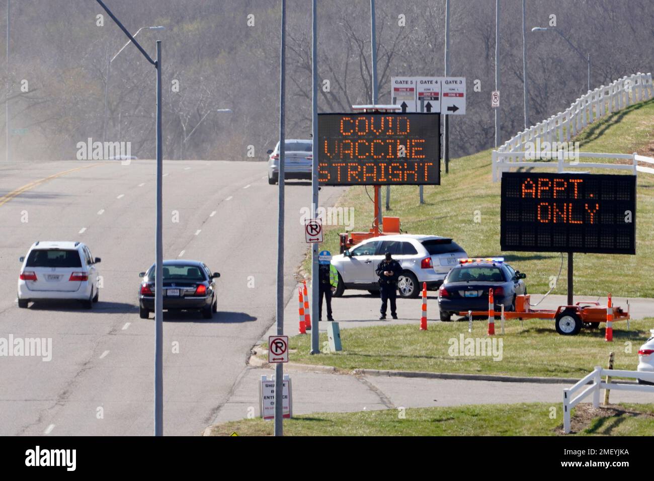 Police man the entrance to a mass COVID-19 vaccination site in Kansas ...