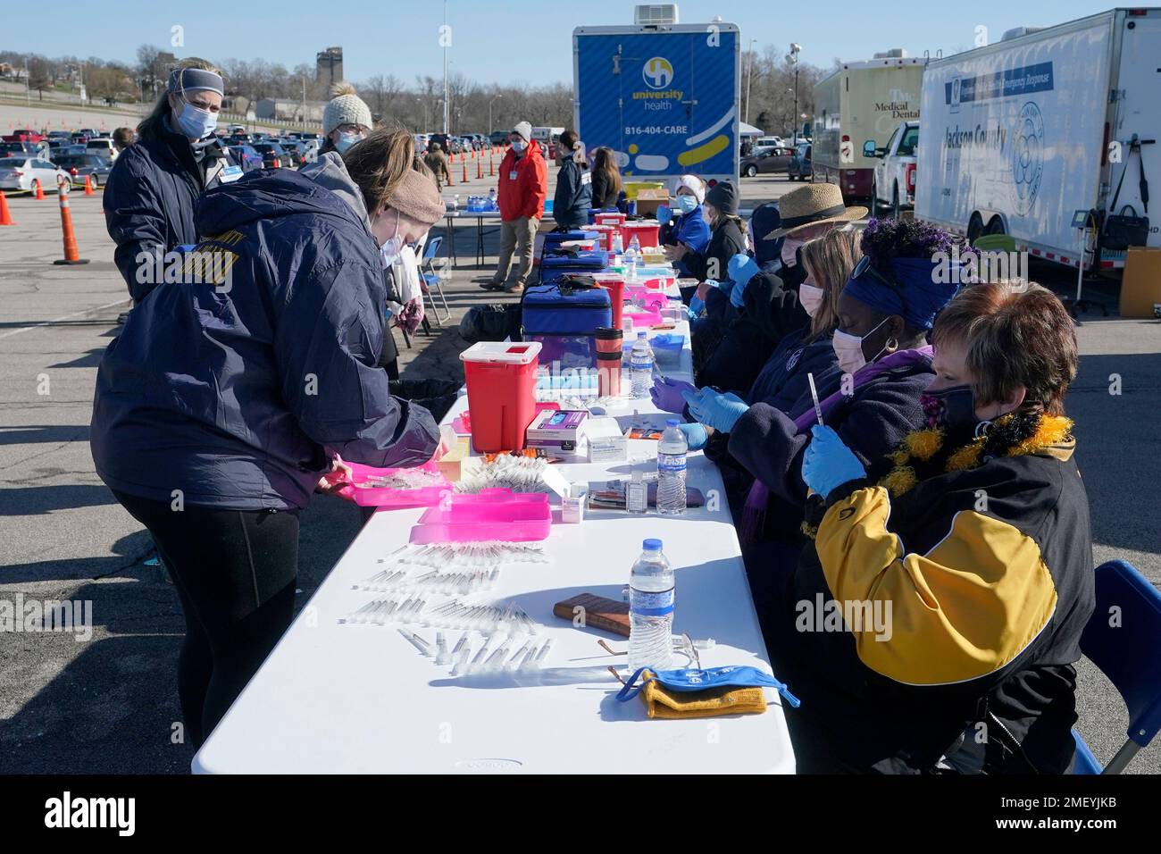 Nurses fill syringes with a COVID-19 vaccine at a mass vaccination site ...