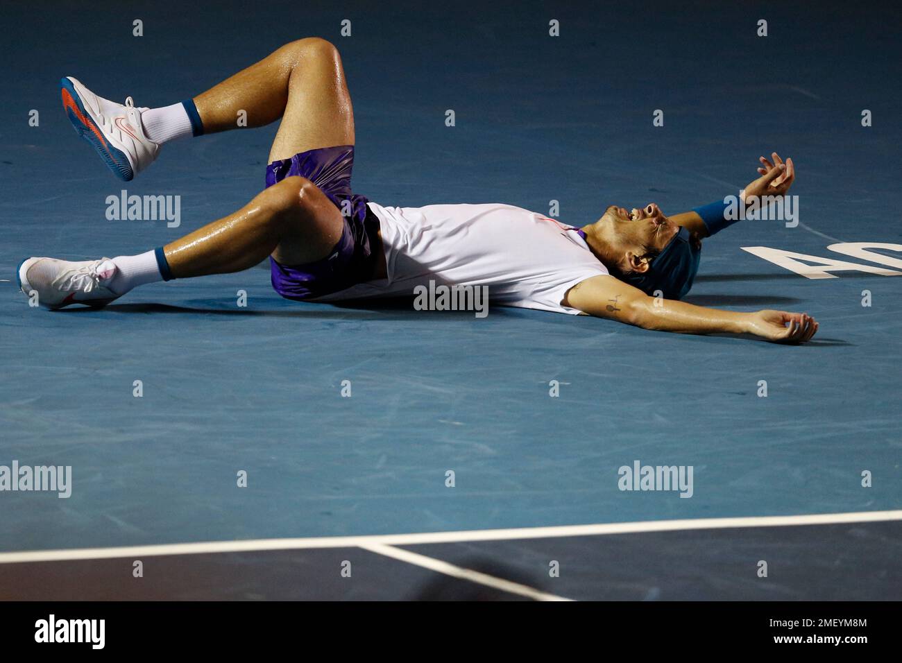 Italy's Lorenzo Musetti rolls on the court as he celebrates winning his ...