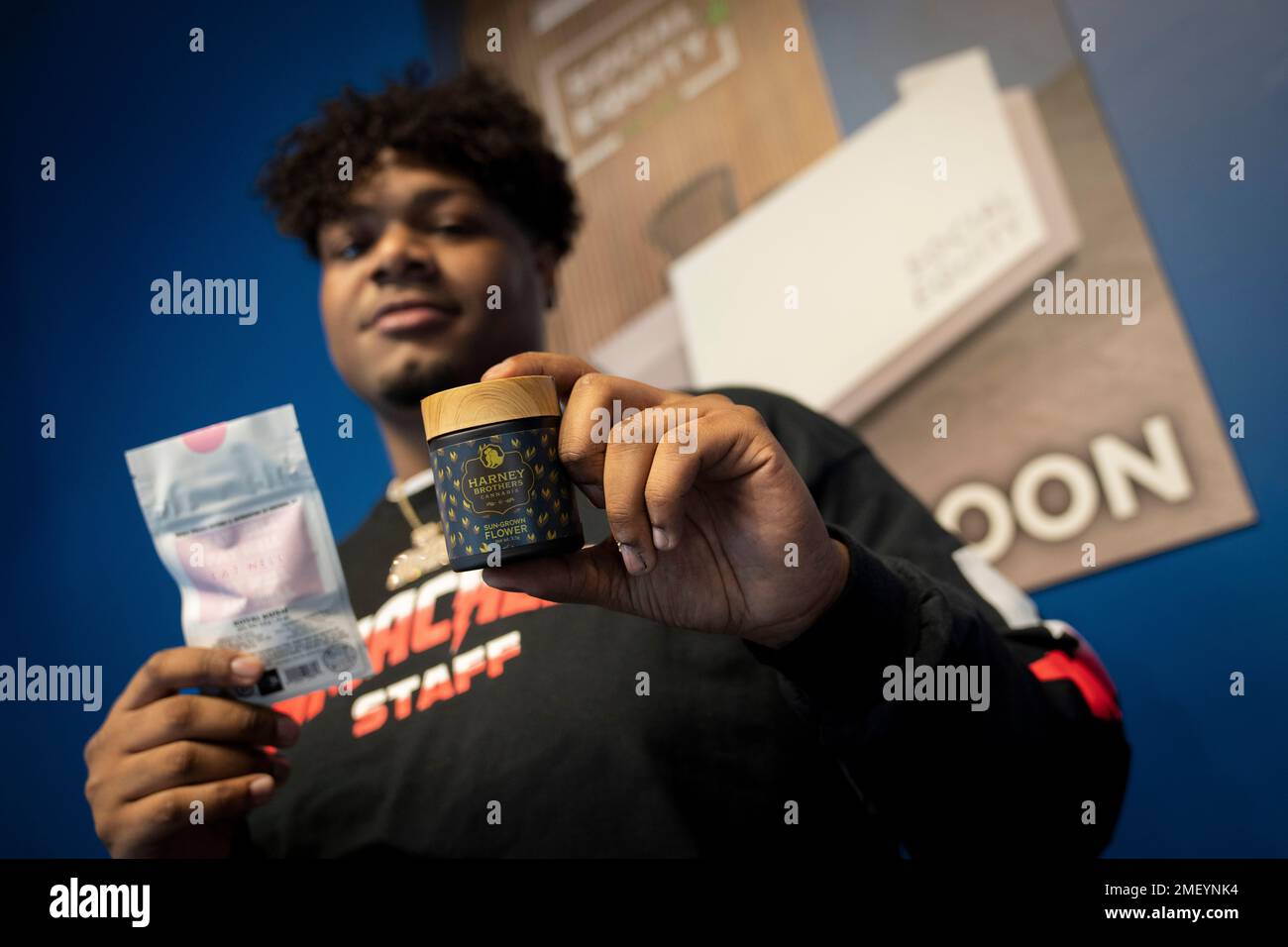 Darius Conner, holds a unit of cannabis flower and a package of ...