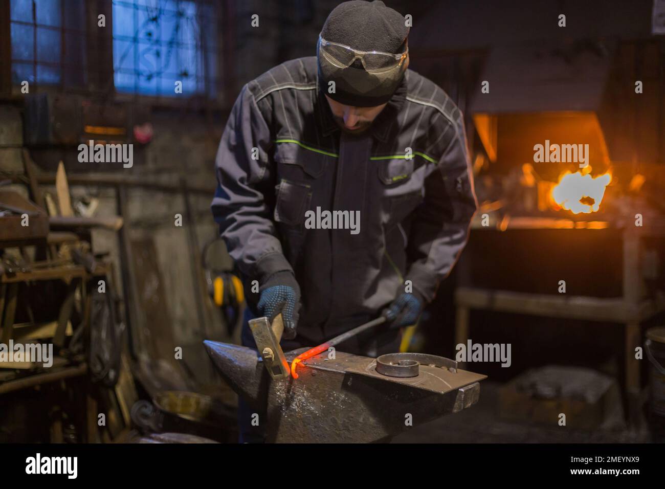 Blacksmith forging molten metal Stock Photo - Alamy