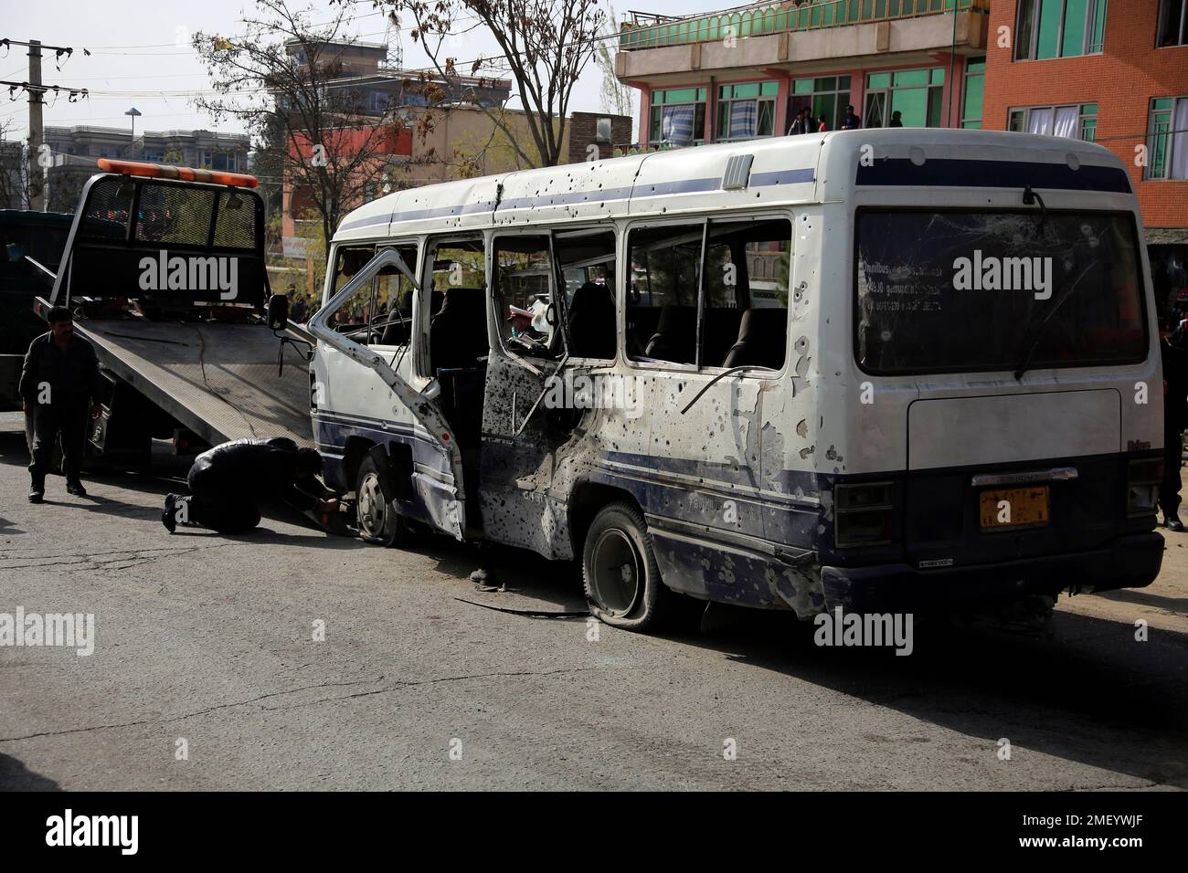 Security personnel remove a damaged minibus after a bomb explosion in ...