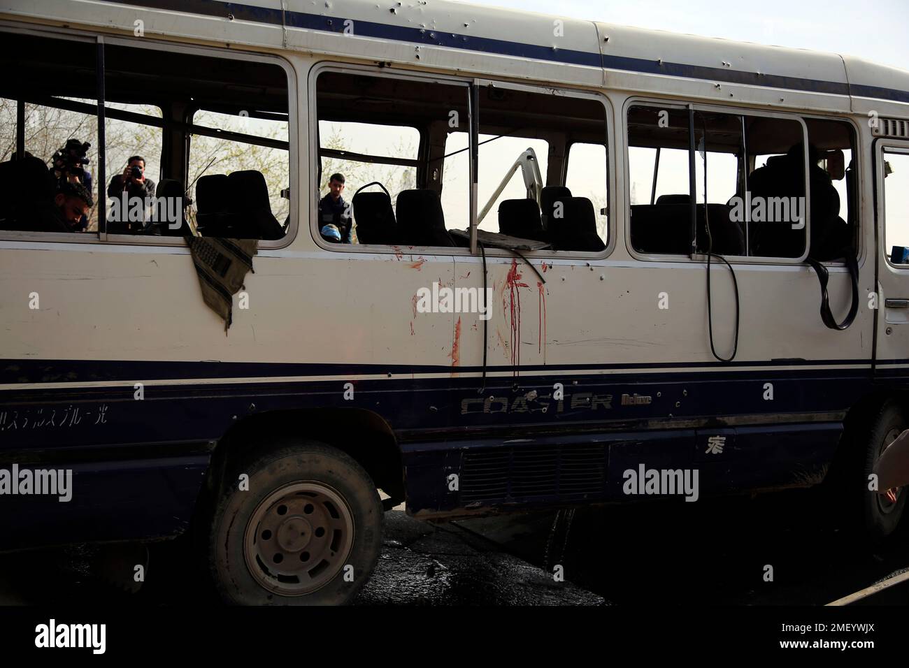 Media take vide3o and photos of a damaged minibus after a bomb ...