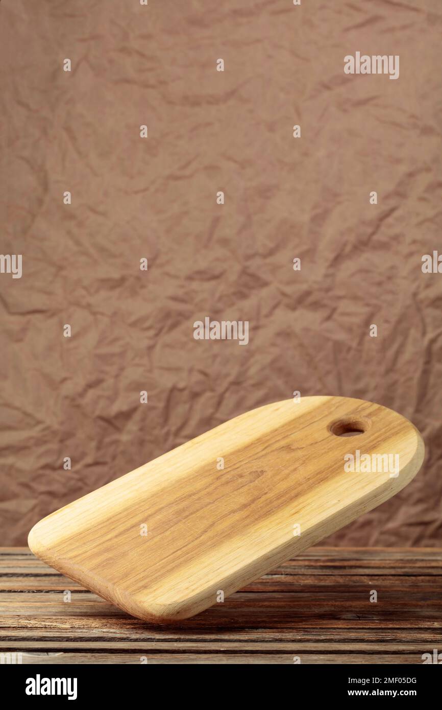 Cutting board falling on an old wooden table. Food preparation ...