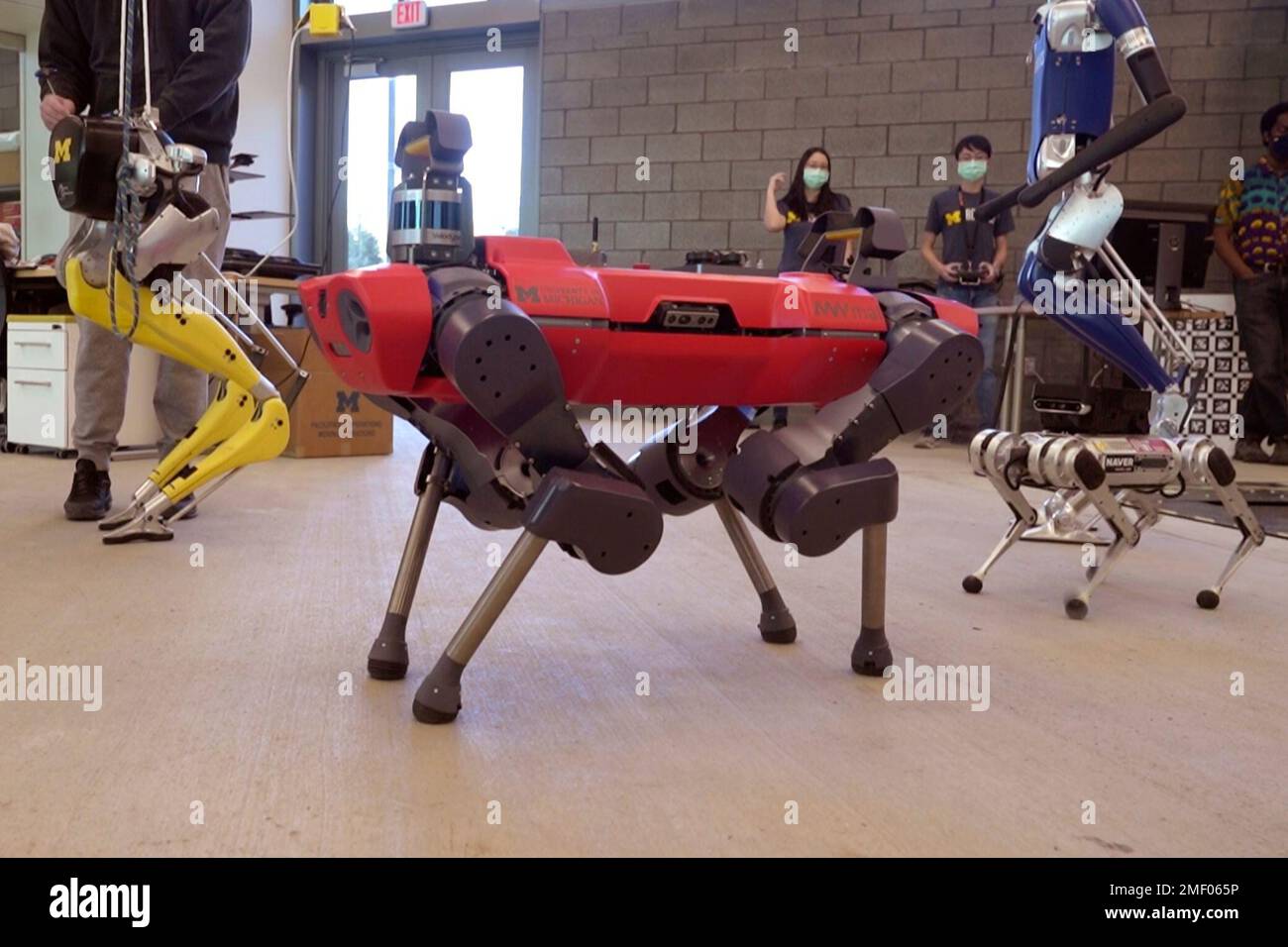 In a frame grab from video, robots walk across the floor of the ...