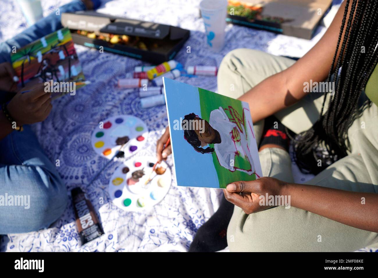Rachel Ruffin, right, paints a portrait of Shatedra Butler as they ...