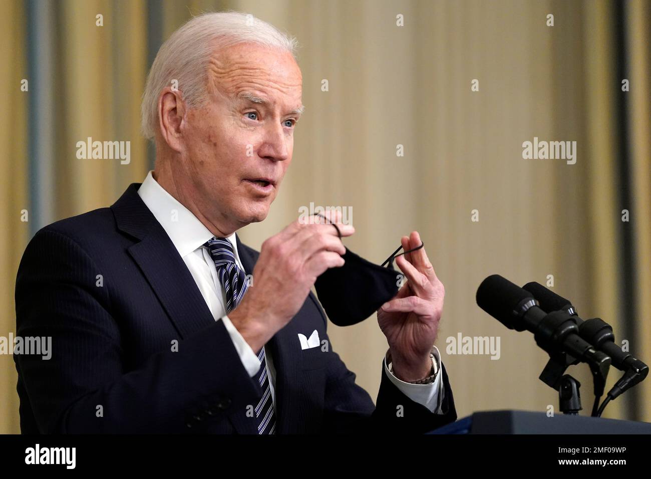 President Joe Biden puts his face mask on after speaking about the ...