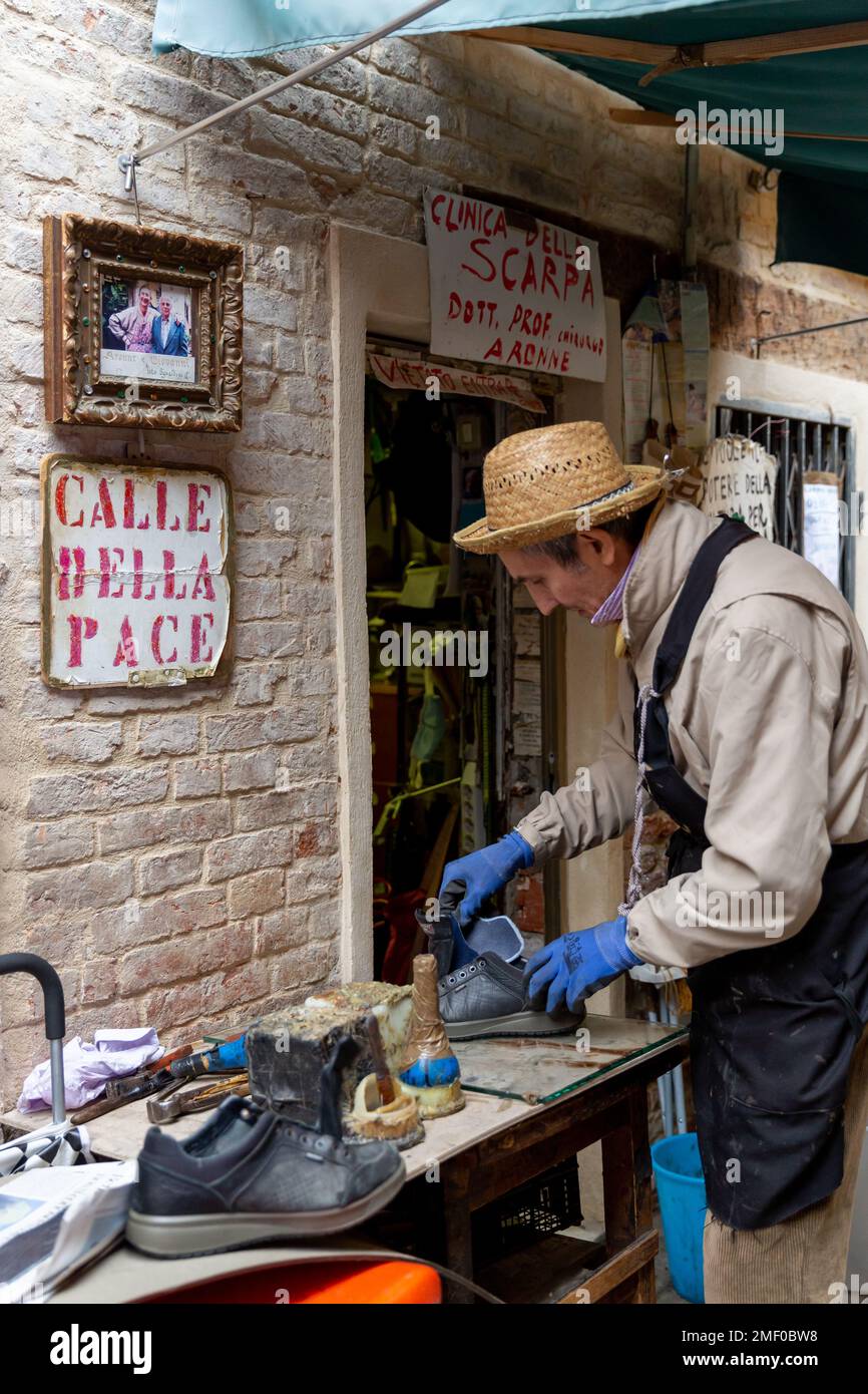 Male shoe cobbler repairing shoes in Venice, Italy Stock Photo - Alamy