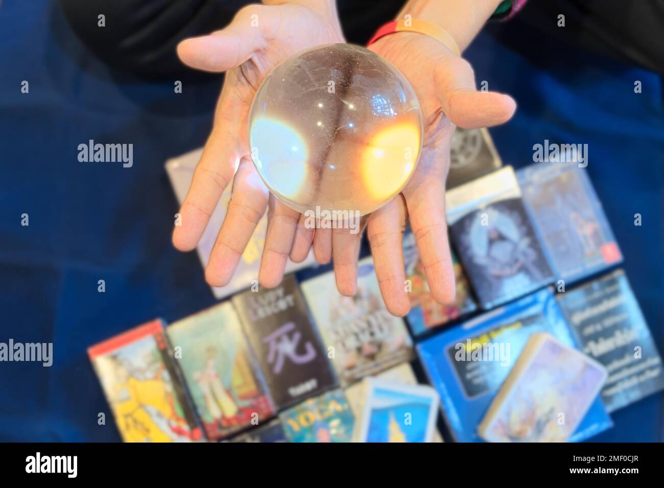 Close-up hands of fortune teller who show clear marble ball for ...