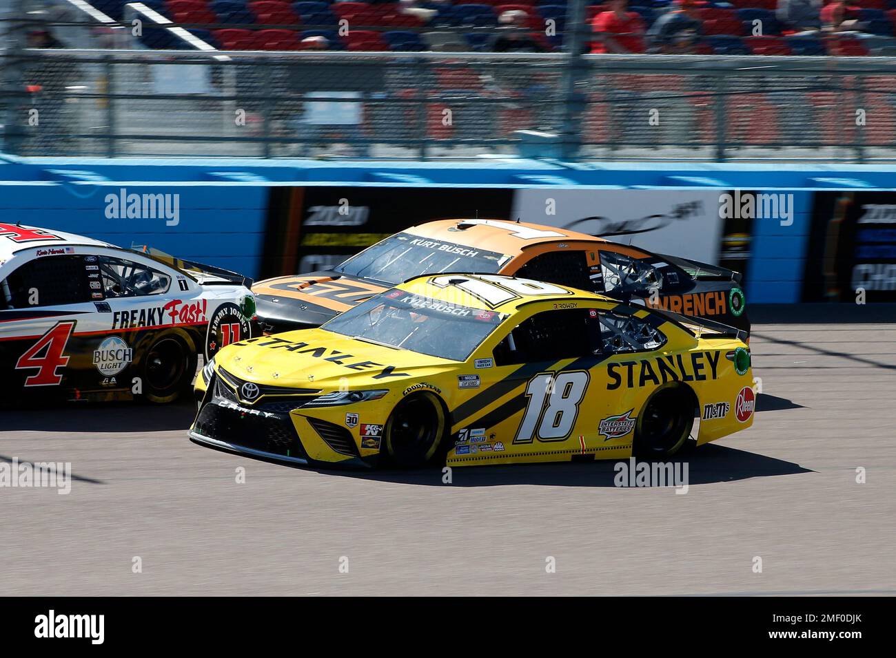 Kyle Busch (18) races Kevin Harvick (4) and Kurt Busch (1) through Turn ...