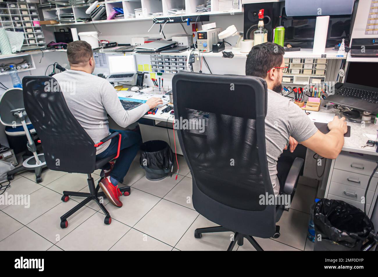 The employees in the workshop do their daily work. A workbench full of ...