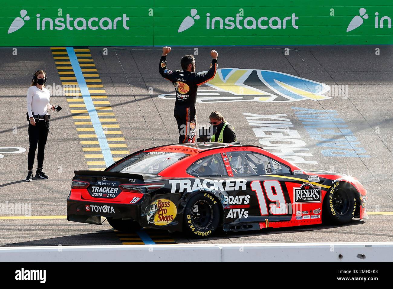 Martin Truex Jr stands on his race car to celebrate winning a NASCAR ...