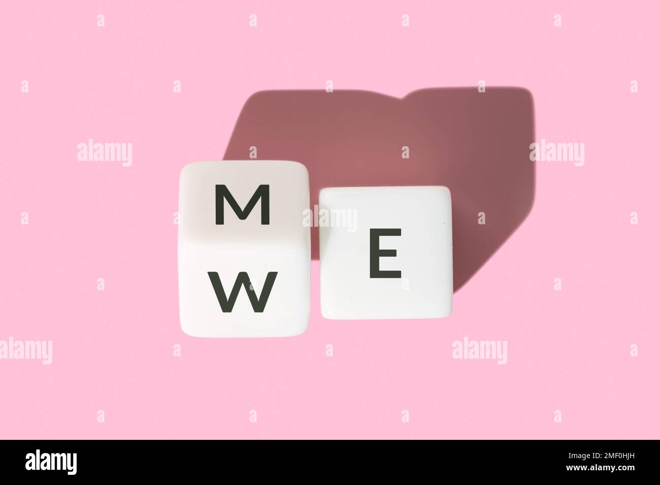 From Me to We concept. Flip cube blocks with text on pink background ...