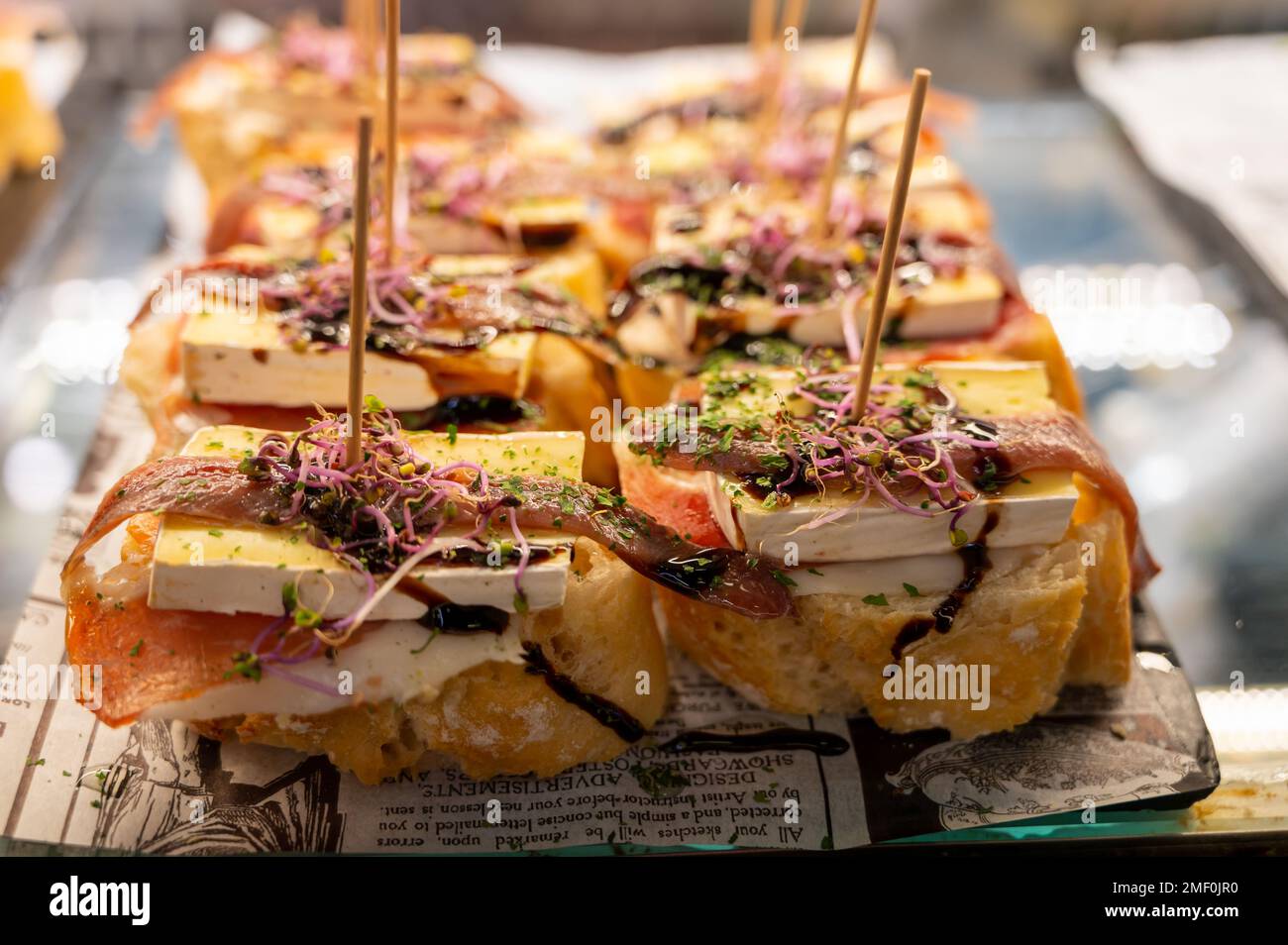 Typical snack of Basque Country, pinchos or pinxtos skewers with small ...