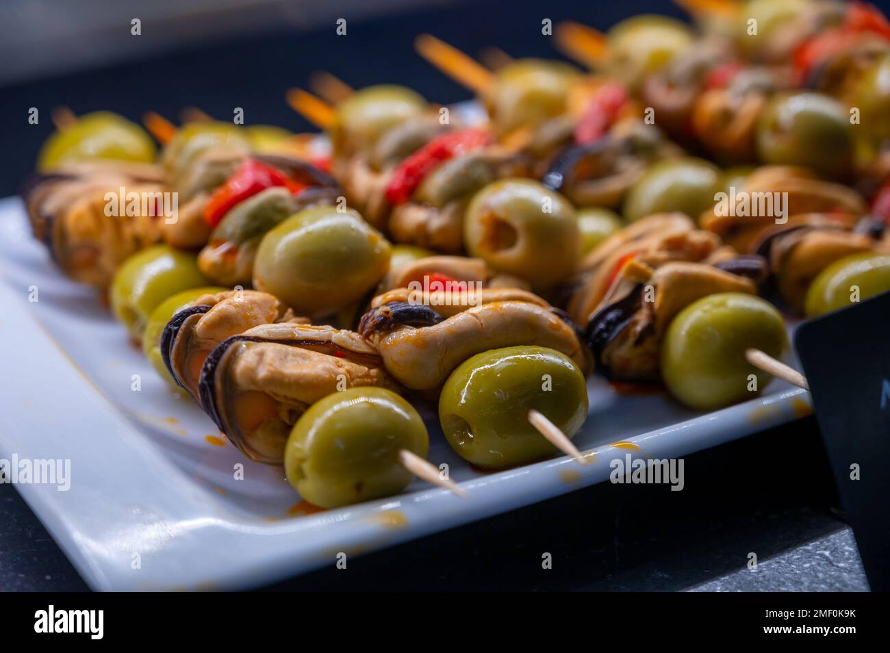 Typical snack of Basque Country, pinchos or pinxtos skewers with small ...