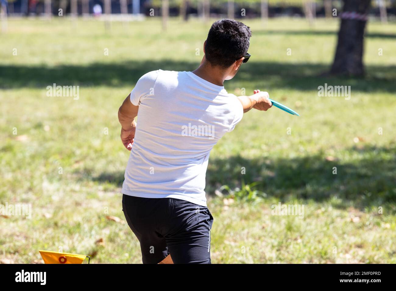 Man playing flying disc golf sport game in the park Stock Photo - Alamy