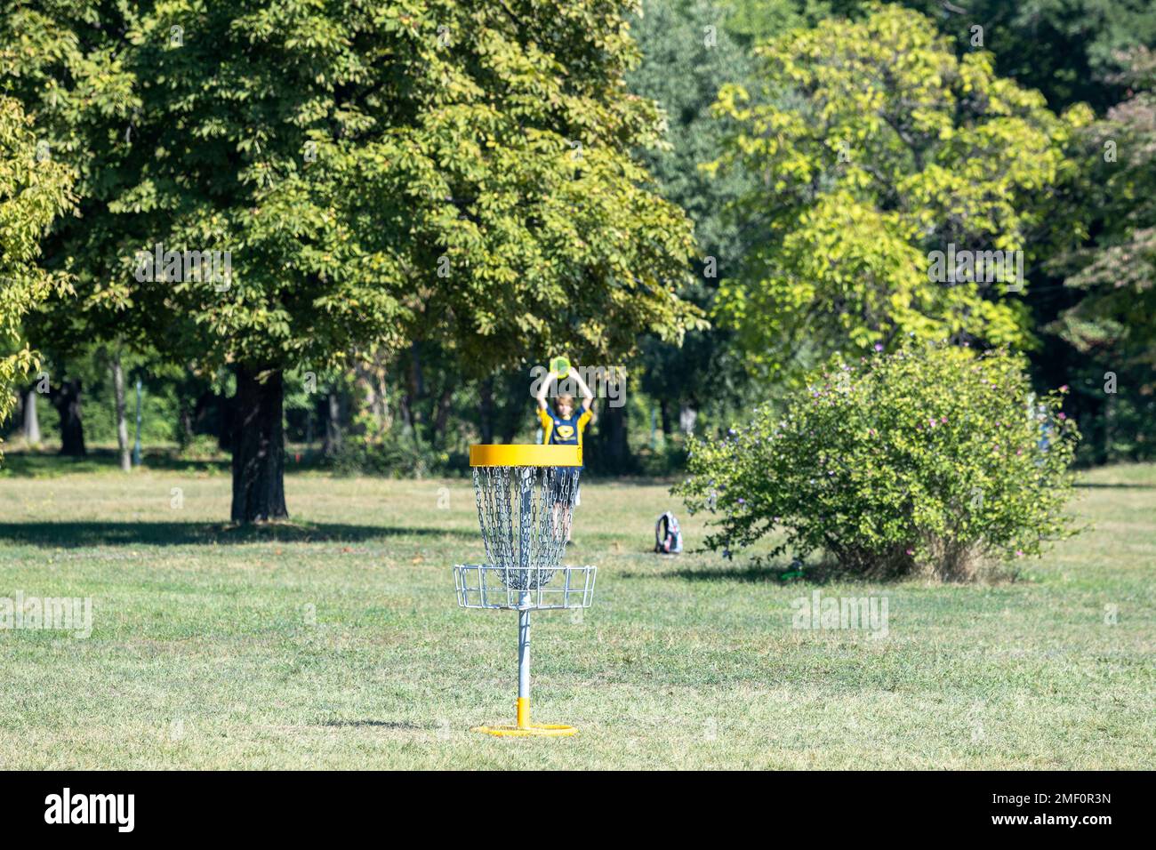 Disc golf player playing a flying disc sport game in the city park ...