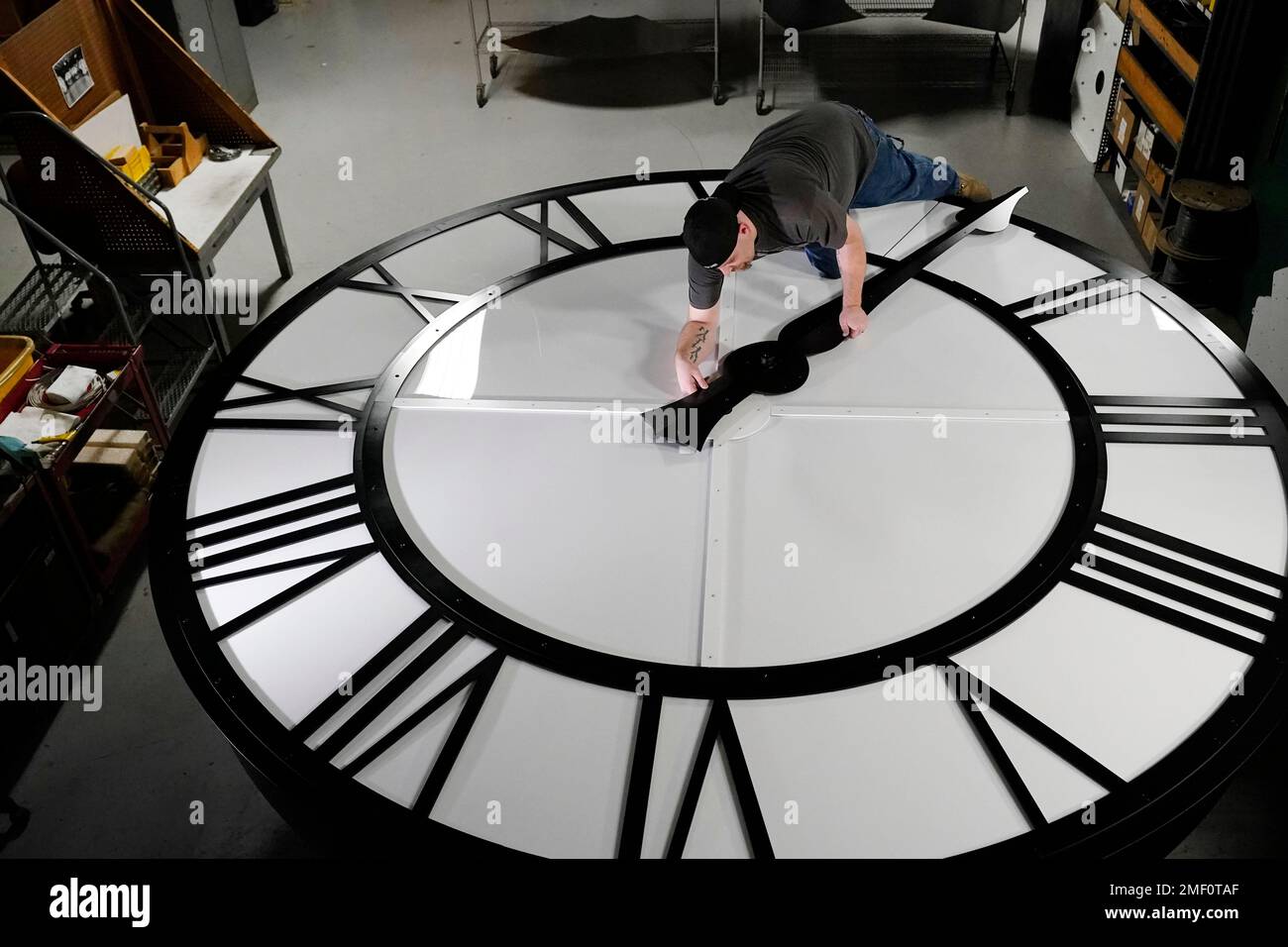 Electric Time technician Dan LaMoore puts a clock hand onto a 1000-lb ...