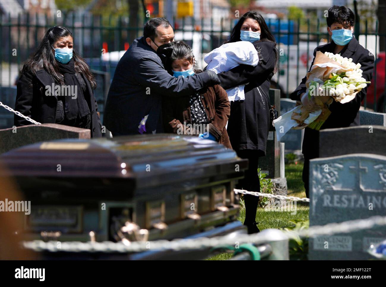 FILE - In this May 12, 2020 file photo, the Rev. Joseph Dutan comforts ...
