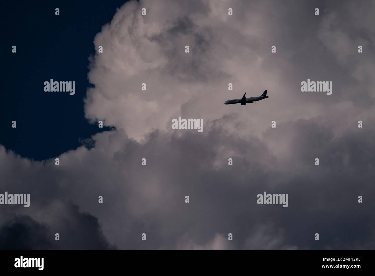 A plane flying through rain clouds is seen from Whittier, Calif ...